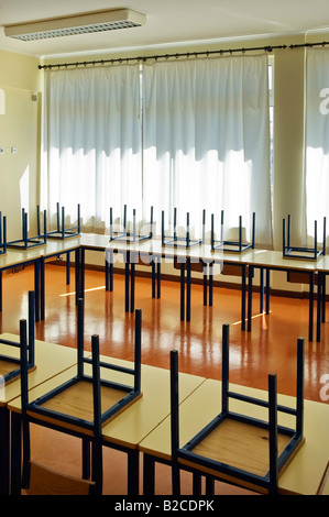 Empty classroom with upside down chairs on desks Stock Photo - Alamy