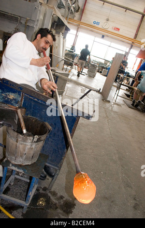 Man blowing glass through rod into mould . 60820 Dartington-Glass Stock ...