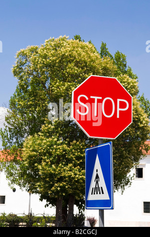 A sign with a red triangle and a blue crosswalk symbol. The sign is on ...