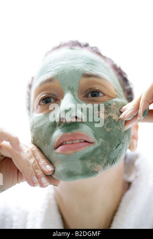 Smiling woman peeling off face mask on white background Stock Photo - Alamy