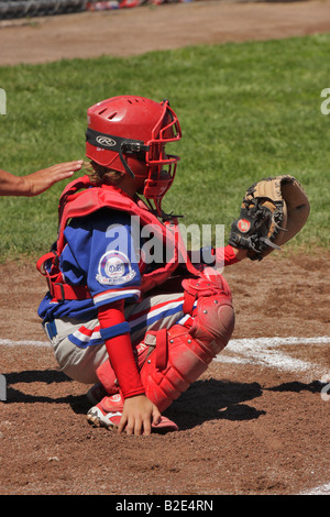 Baseball Catcher behind home plate. Shot from behind a chain link fence ...
