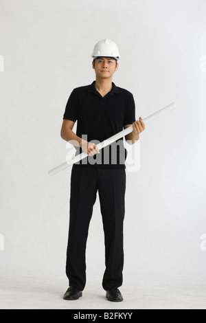 Young male engineer with blueprint on blue background Stock Photo - Alamy