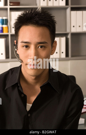 Portrait of a male customer service representative talking on a headset ...