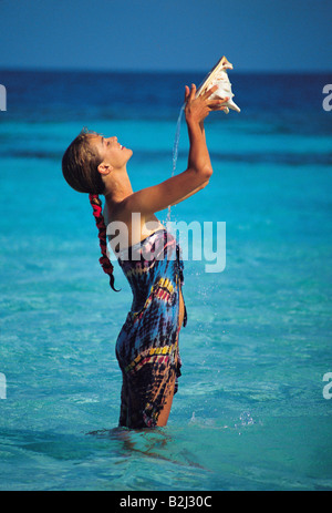Beautiful young woman pouring hot water from modern electric kettle ...