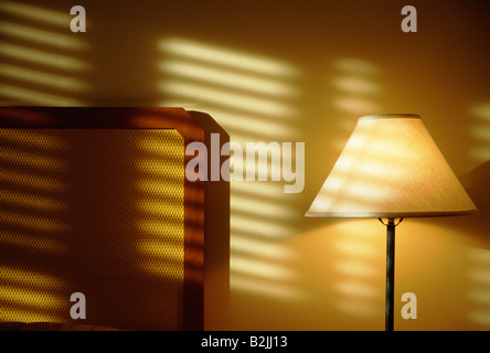 Room in a hotel with a light wall and a striped floor. There is a blue ...