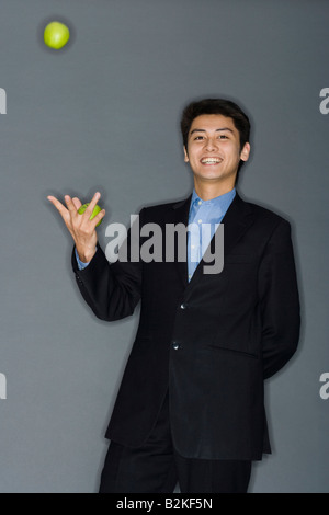 Portrait of a businessman tossing an apple Stock Photo - Alamy