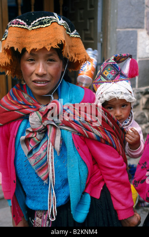 Indian woman carrying child with Inca stone wall, Sacred Valley, Cuzco ...