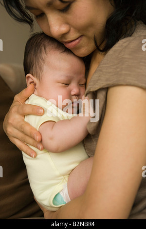 Asian Chinese mother carrying sleeping daughter inside a MRT station in ...