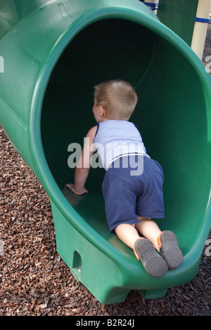 child looking down a tube slide in a playground Stock Photo - Alamy