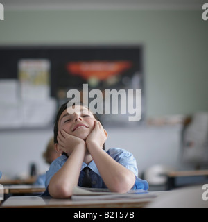 Male elementary school student daydreaming in class Stock Photo - Alamy