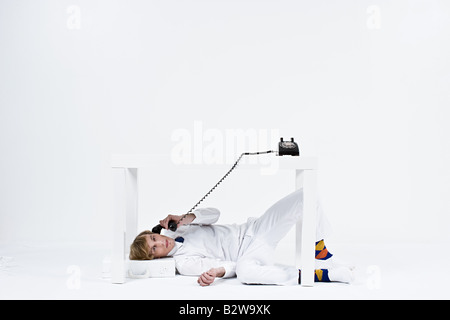 man hiding under desk Stock Photo - Alamy