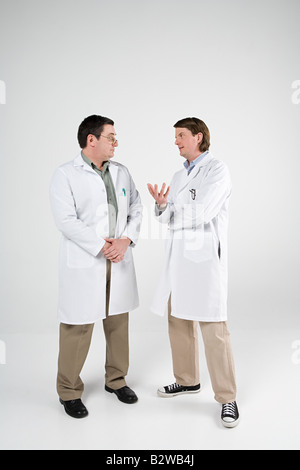 Mature scientist having discussion with colleague in corridor Stock ...