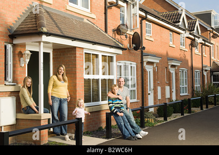 Family Standing Outside Suburban Home Stock Photo - Alamy