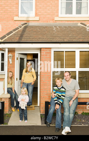 Family standing outside house Stock Photo - Alamy