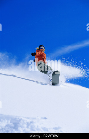 Snowboarder coming down hill smiling Stock Photo - Alamy