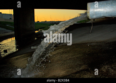 Water flowing from a drain pipe into a small river Stock Photo - Alamy