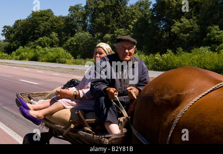 Poor farming couple riding on horse carriage on road from Kiev to Lviv ...