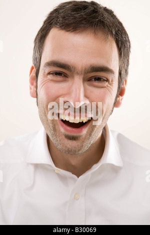 Headshot of attractive man smiling pleased, looking intrigued, standing ...