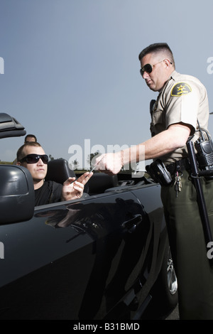 Police officer handing drivers license to man in Mustang Stock Photo ...