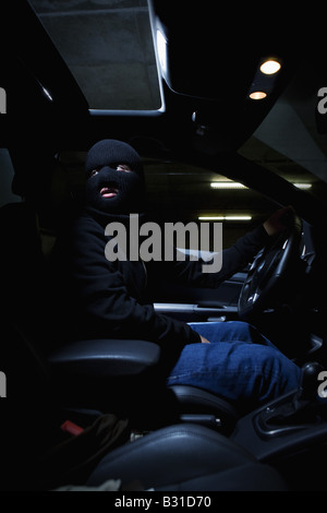 Masked thief sitting in car Stock Photo - Alamy