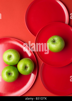 Red and green apples on a plate on a white background. Selective focus ...