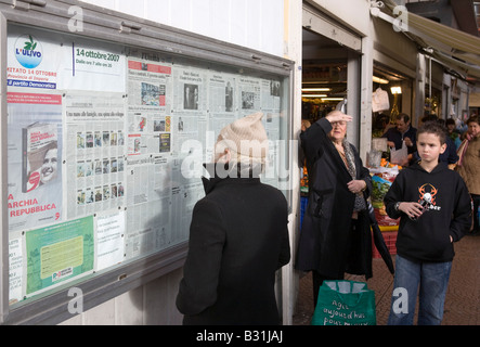 Man reading the leftist newspaper L Unita on display outside the ...