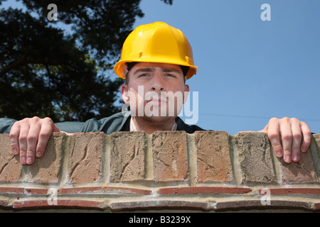 Builder Peering Over a Wall Model Released Stock Photo - Alamy