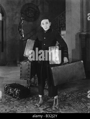 Young bellboy carrying suitcases Stock Photo - Alamy