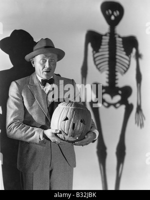 Pumpkins and jack o lantern carved scared pumpkin on hay stack in city ...
