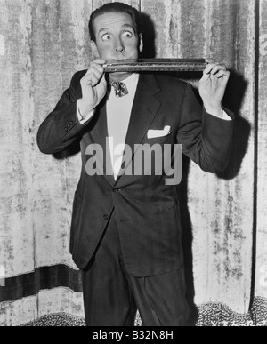Young man blowing harmonica Musical Fun Stock Photo - Alamy