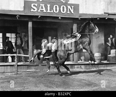 Man falling off bucking horse at rodeo Stock Photo - Alamy