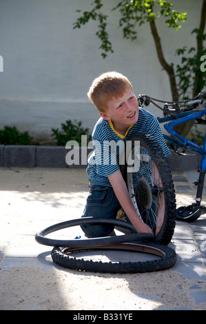 Boy fixing a puncture on his bicycle, removing the inner tube Stock ...