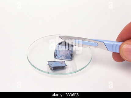 Cutting sodium metal. Freshly cut, shiny surface of a sample of sodium ...