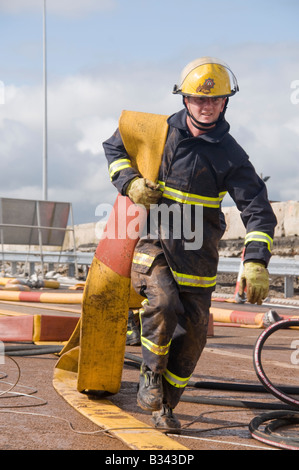 Firemen pull a hose into position Stock Photo - Alamy