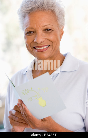 Smiling woman reading thank you card Stock Photo - Alamy