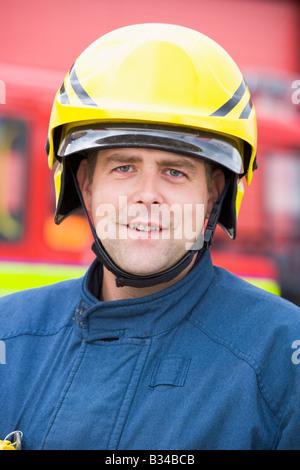 Fireman standing by fire engine wearing helmet Stock Photo - Alamy