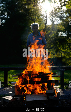Woman warming herself at an open fire in a Finnish log cabin Stock ...