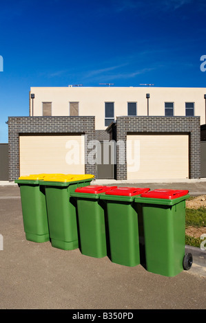 Two waste collection bins, one grey and one green, stand in a natural ...