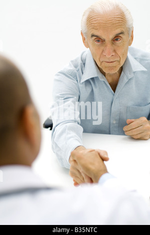 Elderly and younger man sitting on a panel and talking isolated on ...