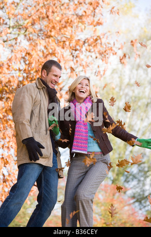 Young man, woman playing, throwing snowballs in winter snowstorm, storm ...