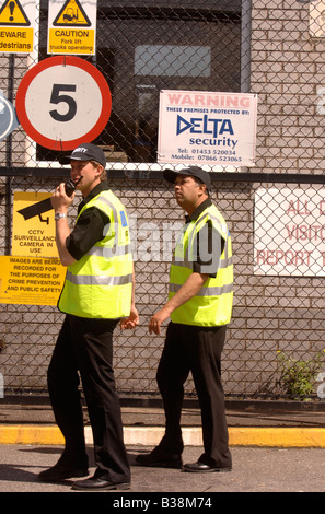 TWO SECURITY GUARDS PATROL THE PERIMETER OF SECURE PREMISES UK Stock ...