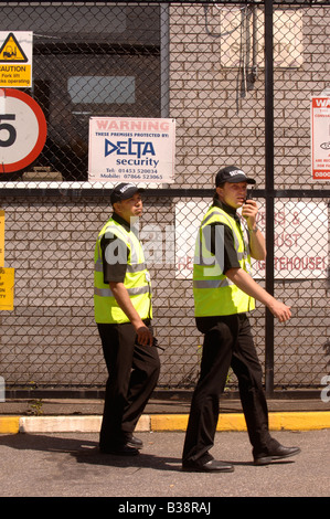 TWO SECURITY GUARDS PATROL THE PERIMETER OF SECURE PREMISES UK Stock ...