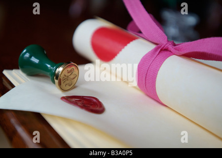 Scroll of legal documents bound in pink ribbon with wax seals and a ...