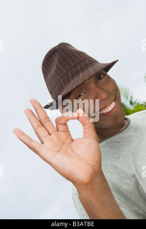 Hispanic man making ok gesture with hand in front of eye, in front of ...