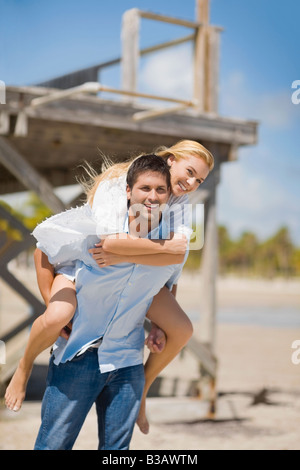 Hispanic man giving girlfriend piggy back ride Stock Photo - Alamy