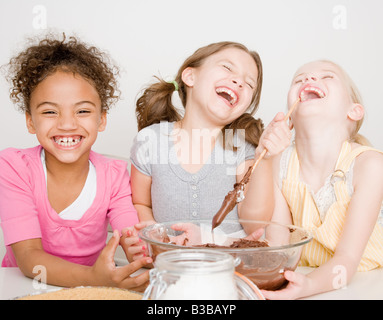 Multi-ethnic girls making batter Stock Photo - Alamy