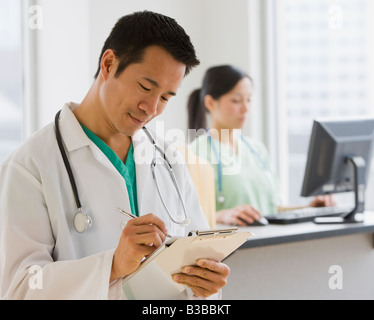 Asian healthcare worker writing medical notes documentation at desk in ...