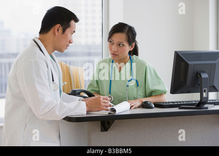 Asian healthcare worker talking on phone in bright modern office ...