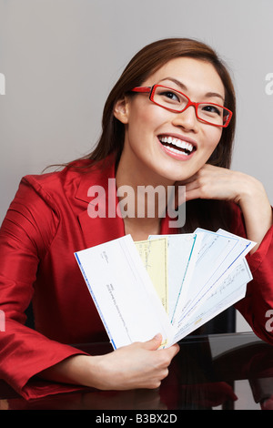 Asian businesswoman holding checks Stock Photo - Alamy