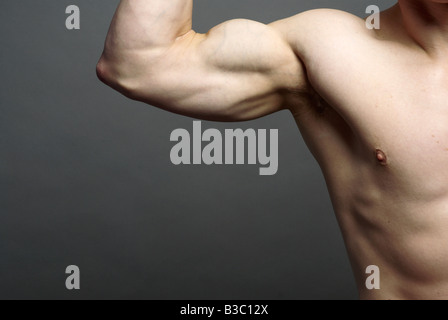 A man tensing his bicep muscle Stock Photo - Alamy